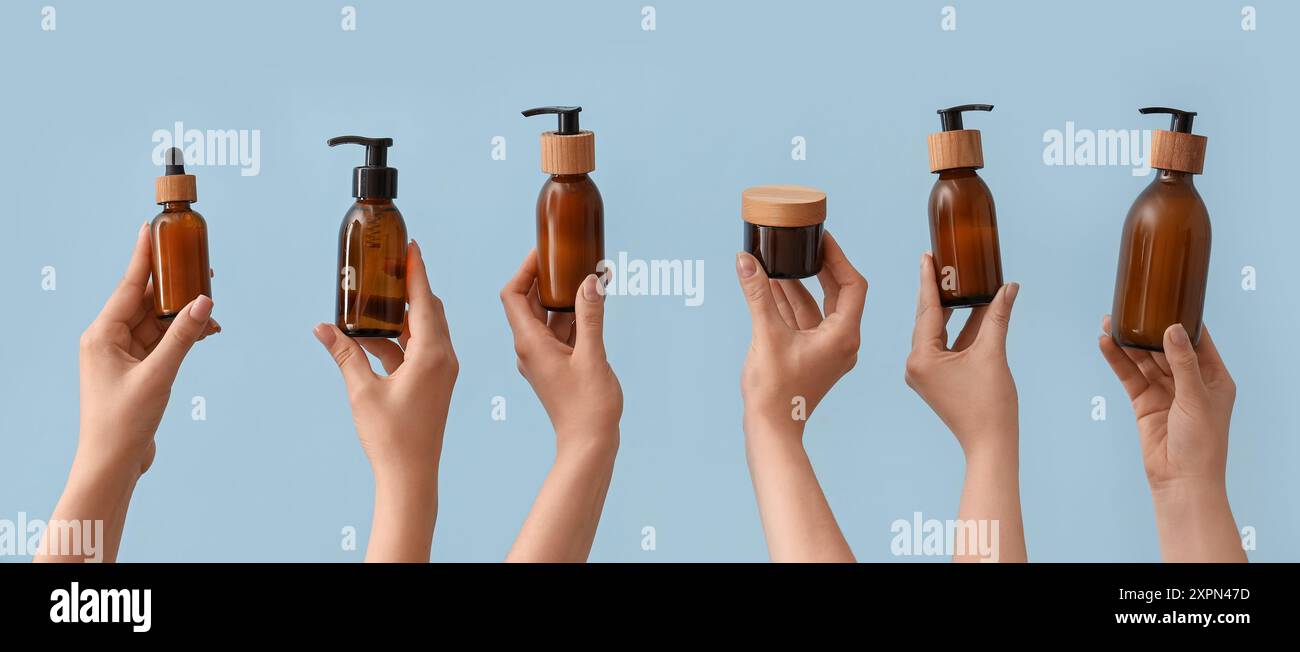 Many hands with different cosmetic products on light blue background ...