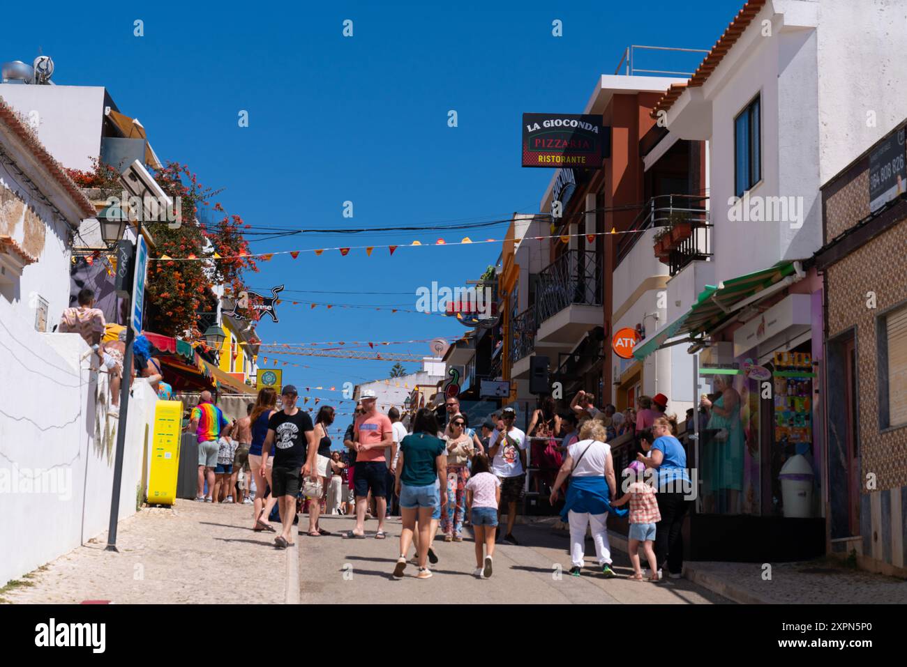 Alvor Portugal busy main street in Algarve town with tourists and cafes ...