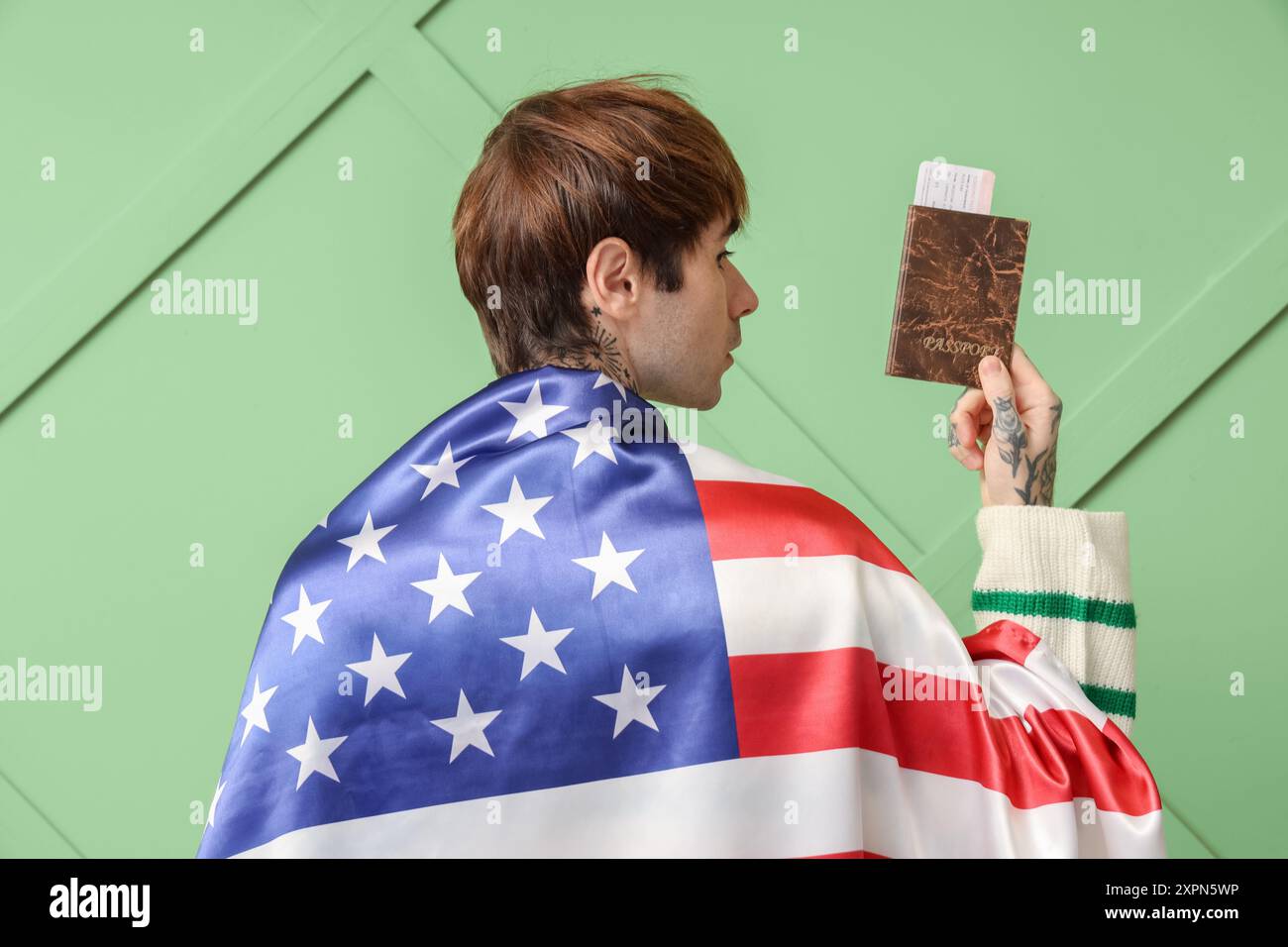 Handsome young man with USA flag and passport on green background, back ...