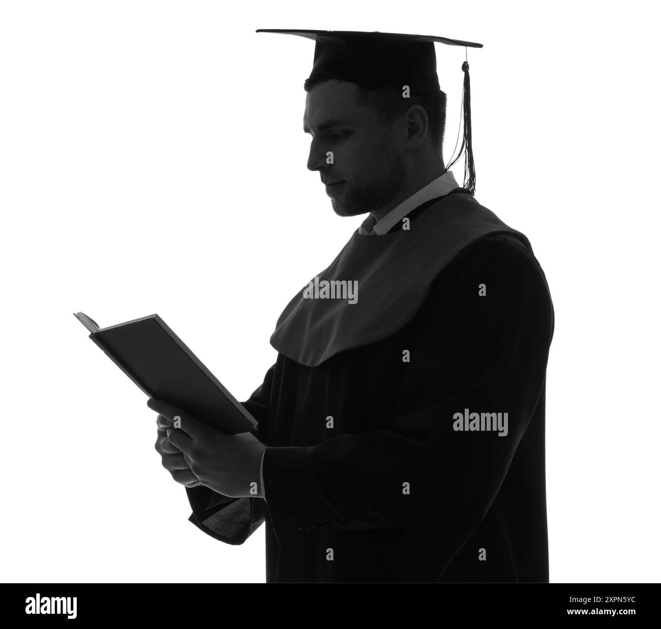 Silhouette of graduating student reading book on white background Stock ...