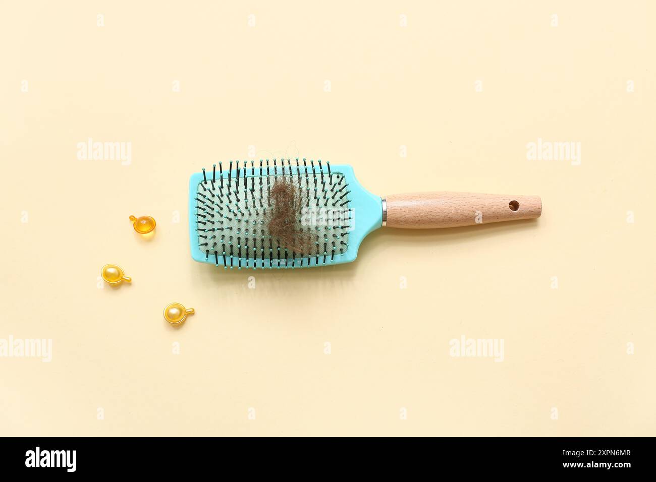Brush, capsules and hair clump on beige background Stock Photo - Alamy