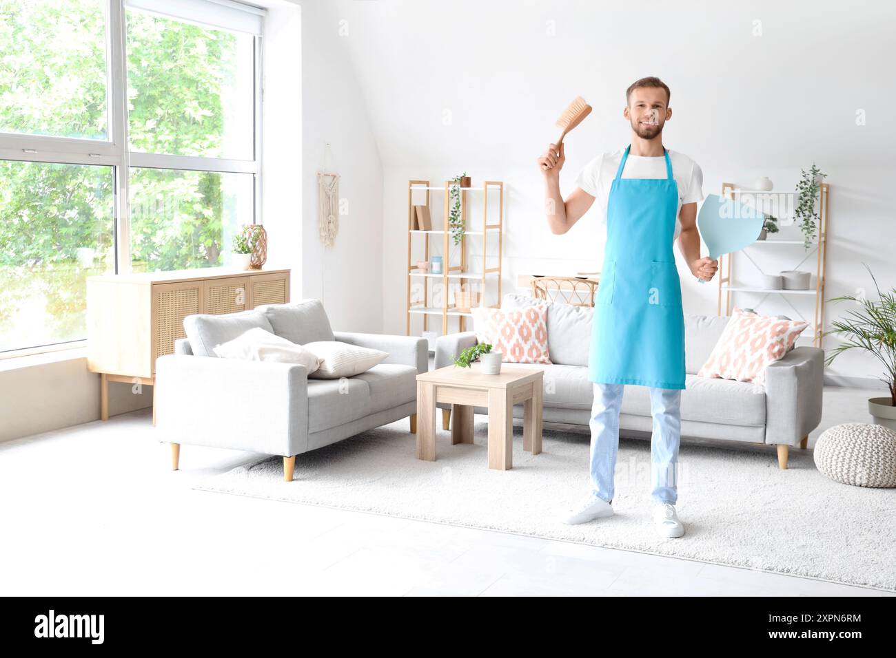 Male janitor with dust pan and brush in light room Stock Photo - Alamy
