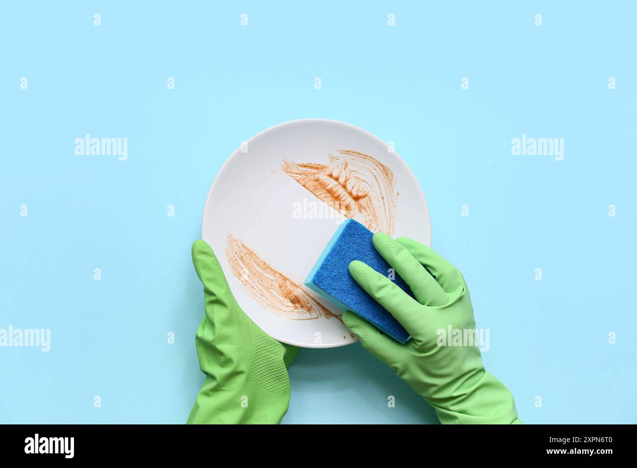 Hands washing dishes on blue background Stock Photo - Alamy