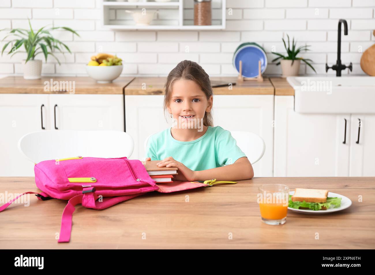 Little girl packing backpack for school in kitchen Stock Photo - Alamy
