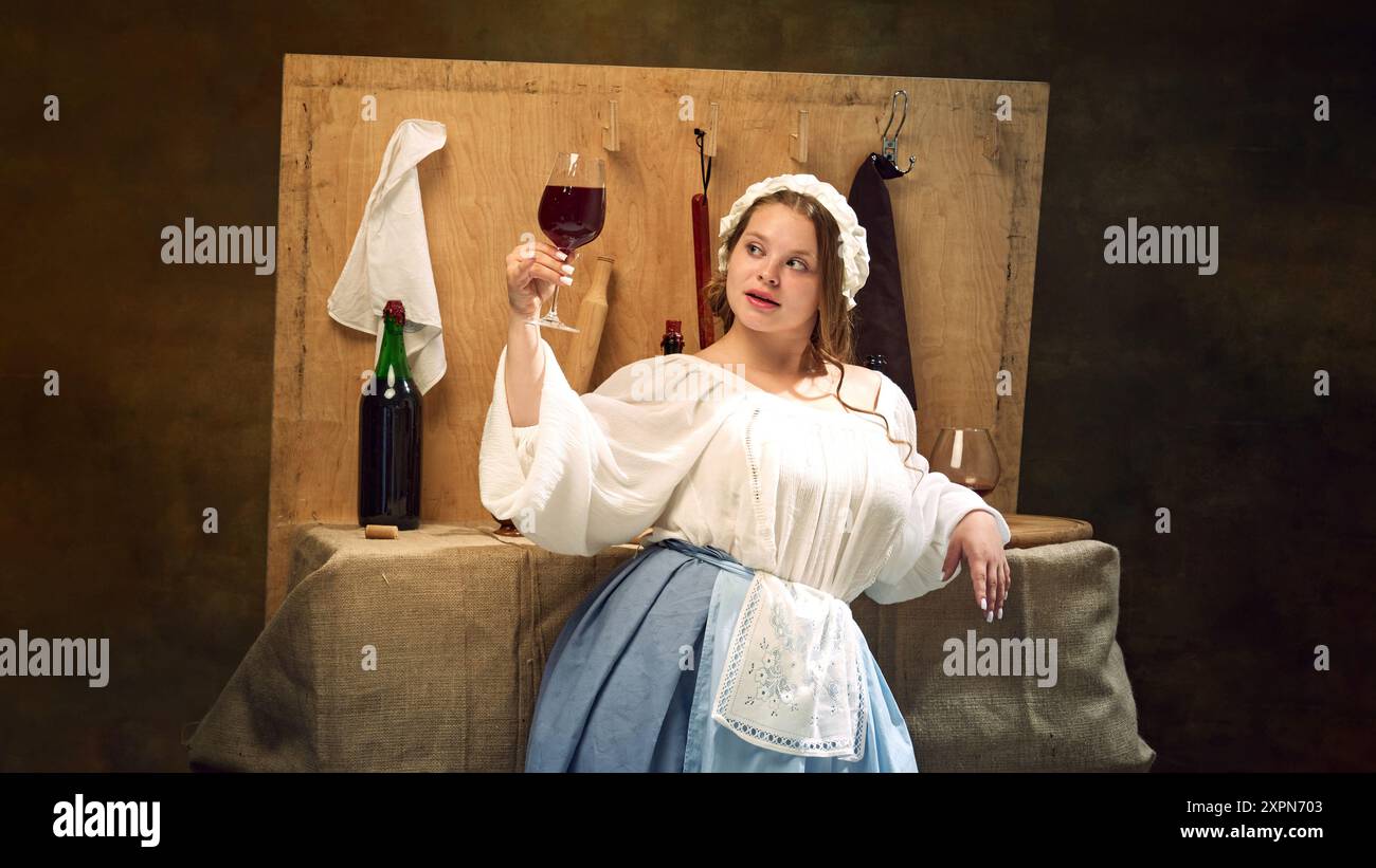 Young chubby medieval woman in vintage clothes holding glass of wine ...