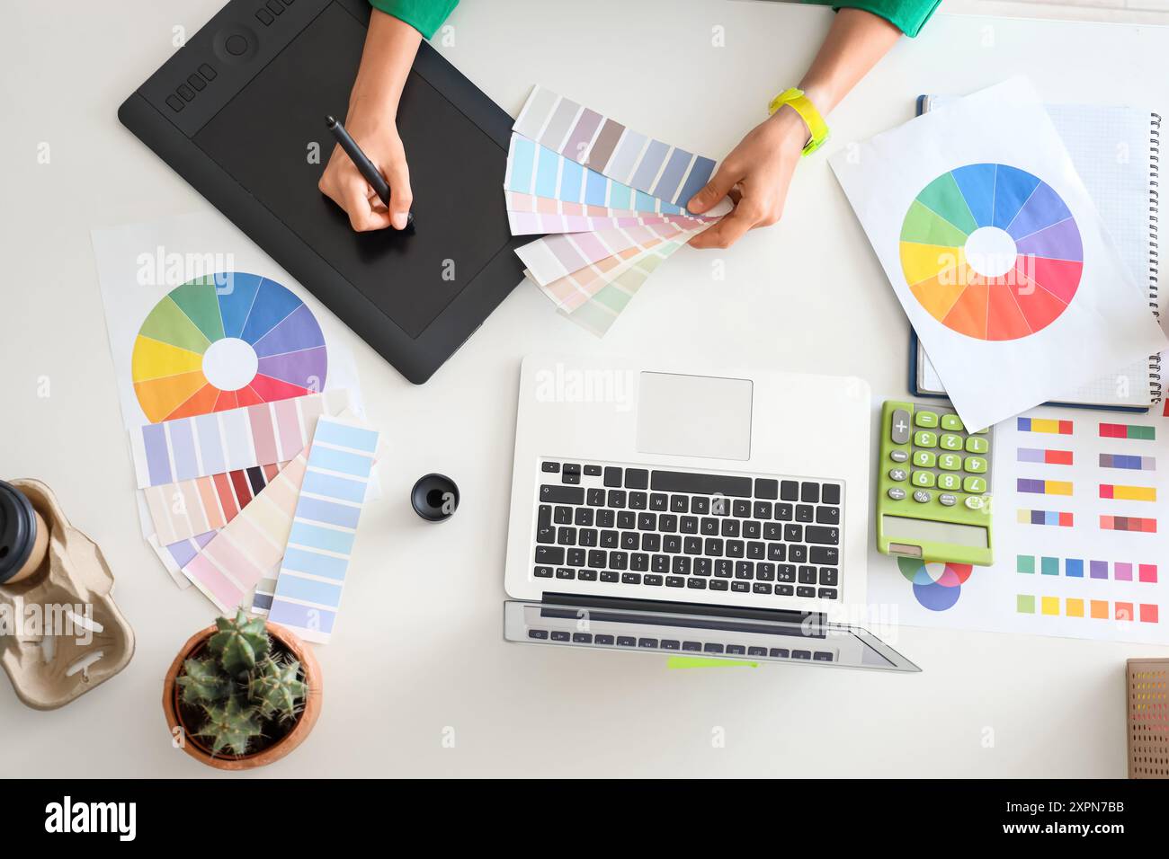 Graphic designer working with tablet and color palettes on table, top ...