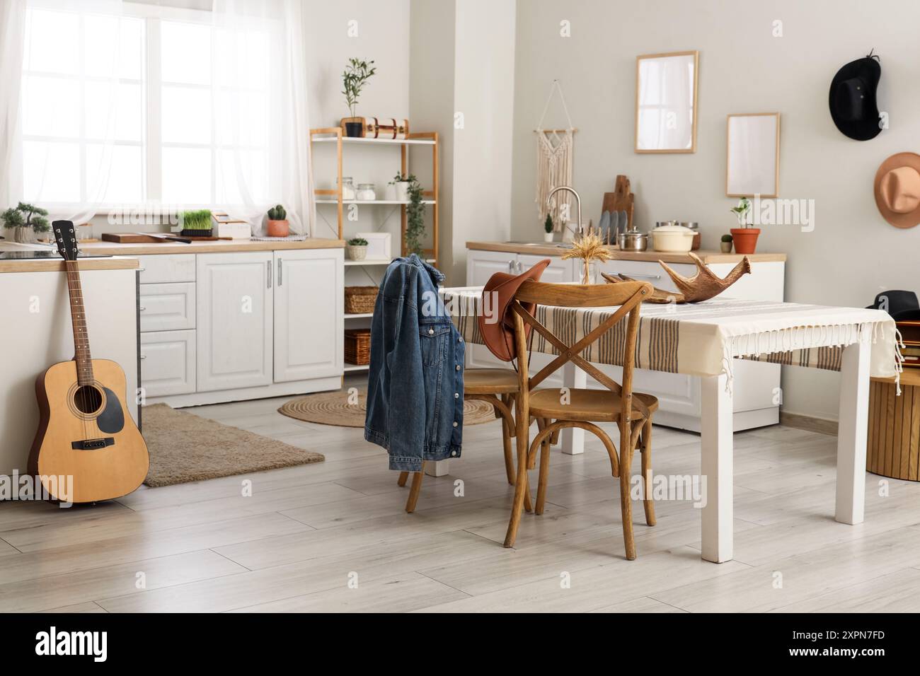 Interior of kitchen with dining table, cowboy hat and denim jacket on ...