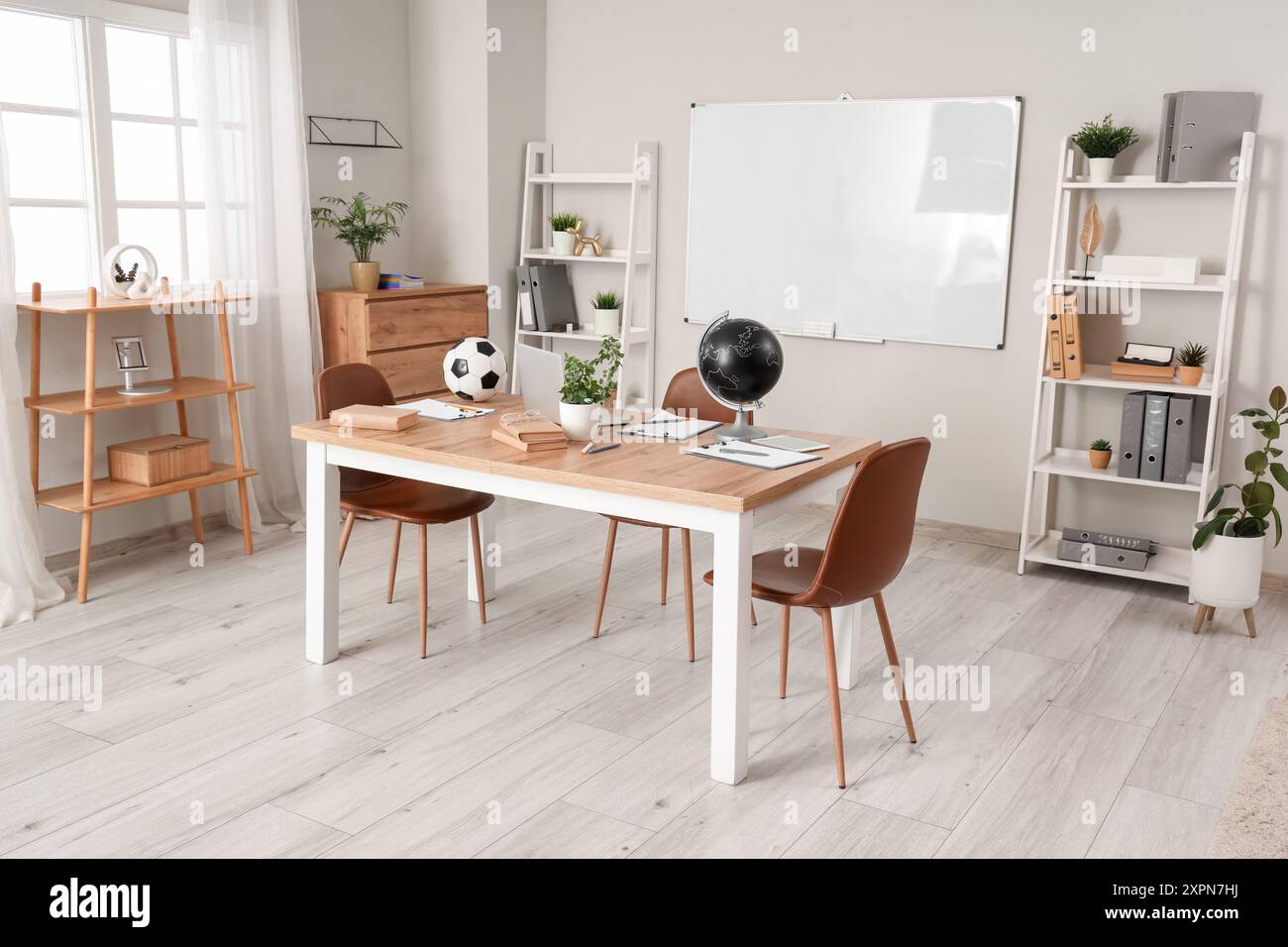 Interior of school office with teacher's table, whiteboard and shelf ...