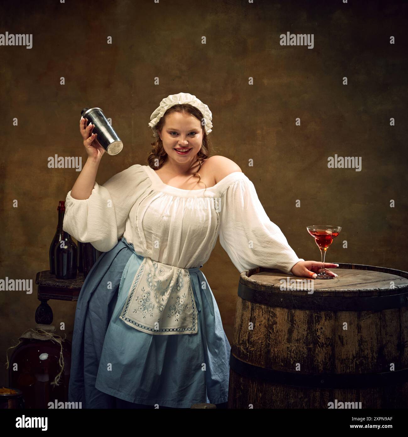 Medieval woman, bar tender, in traditional attire shaking cocktail ...