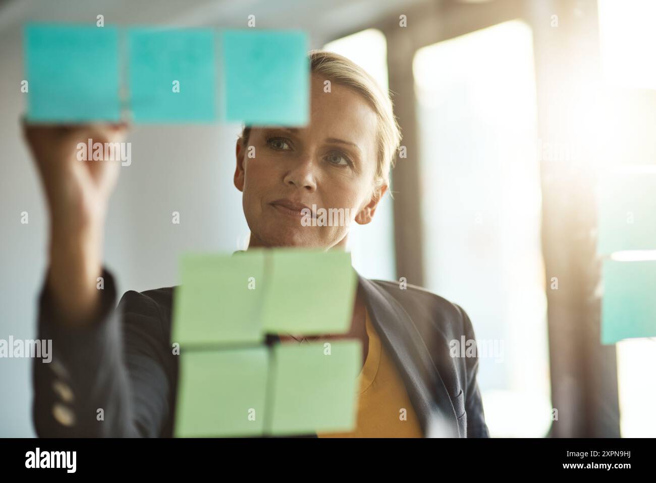 Planning, sticky notes and window with business woman in office for ...