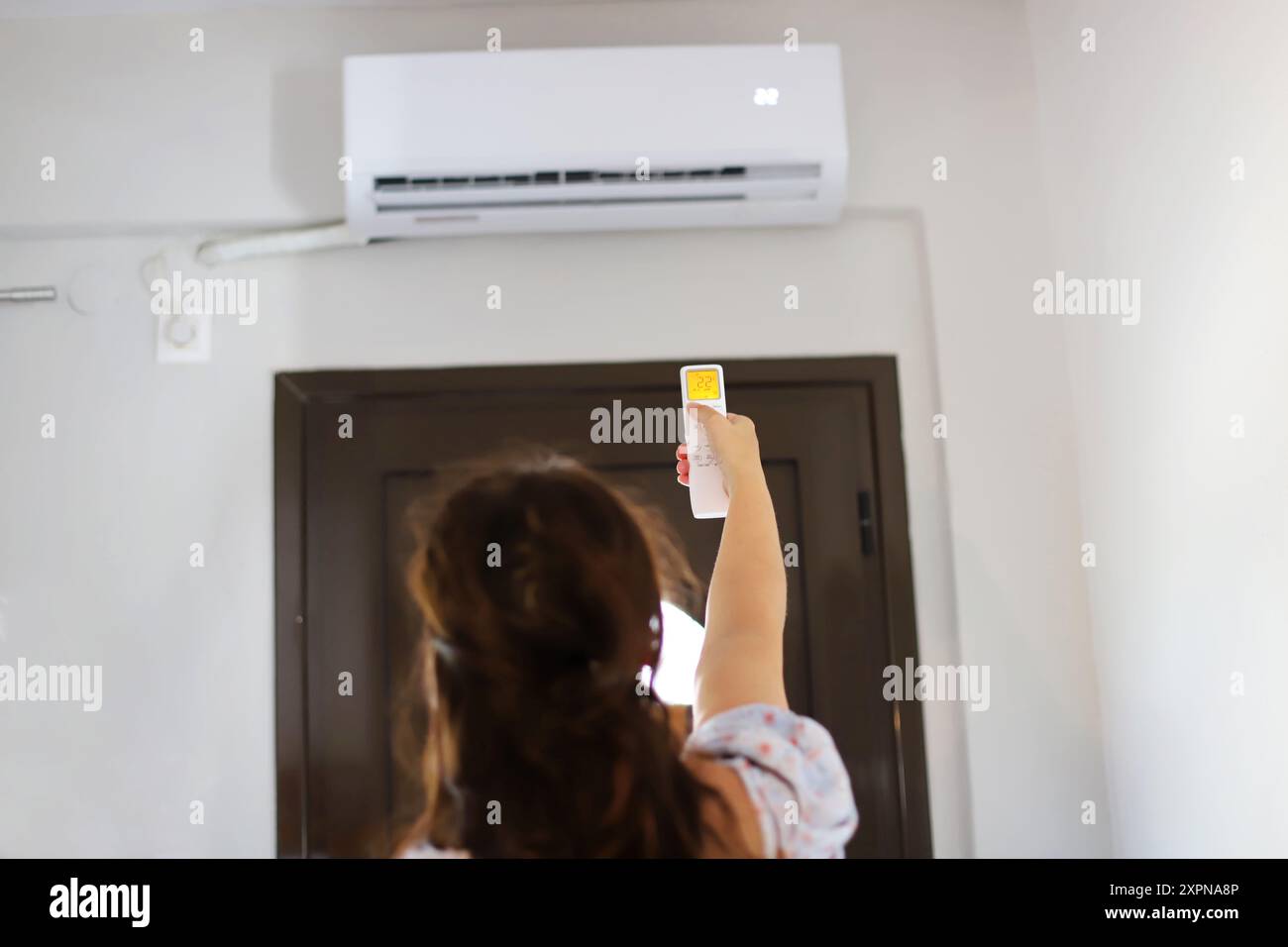 Woman air conditioner remote hi-res stock photography and images - Alamy