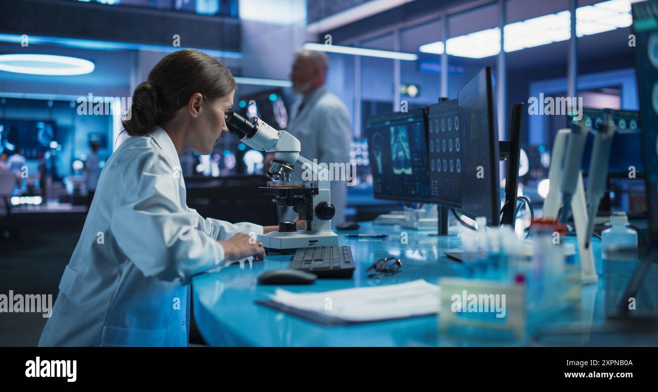 Doctor analyzes sample using microscope hi-res stock photography and ...