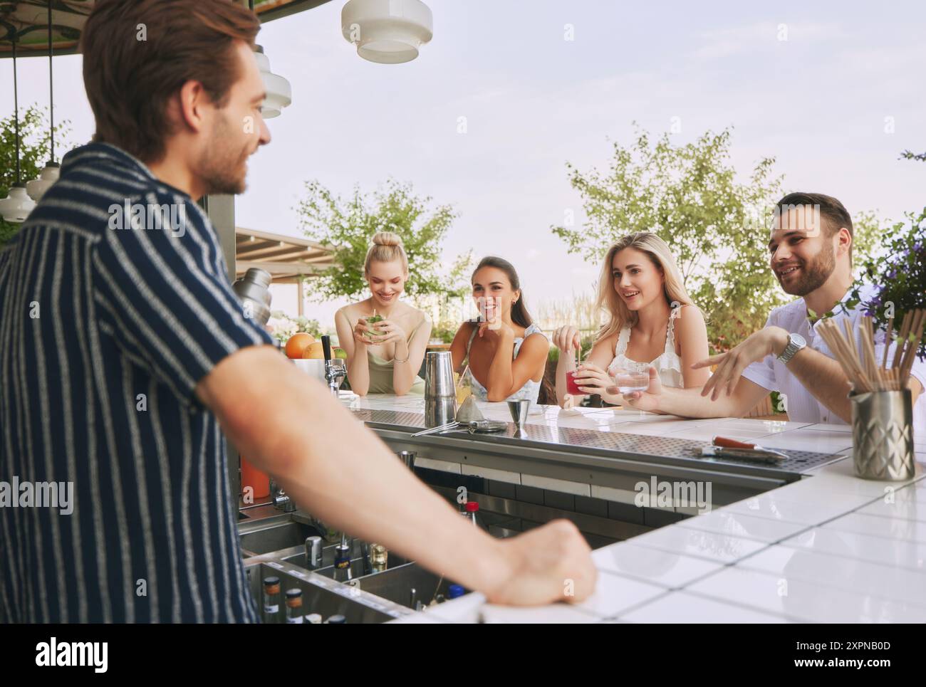 Young people, friends meeting in modern bar, open air restaurant ...