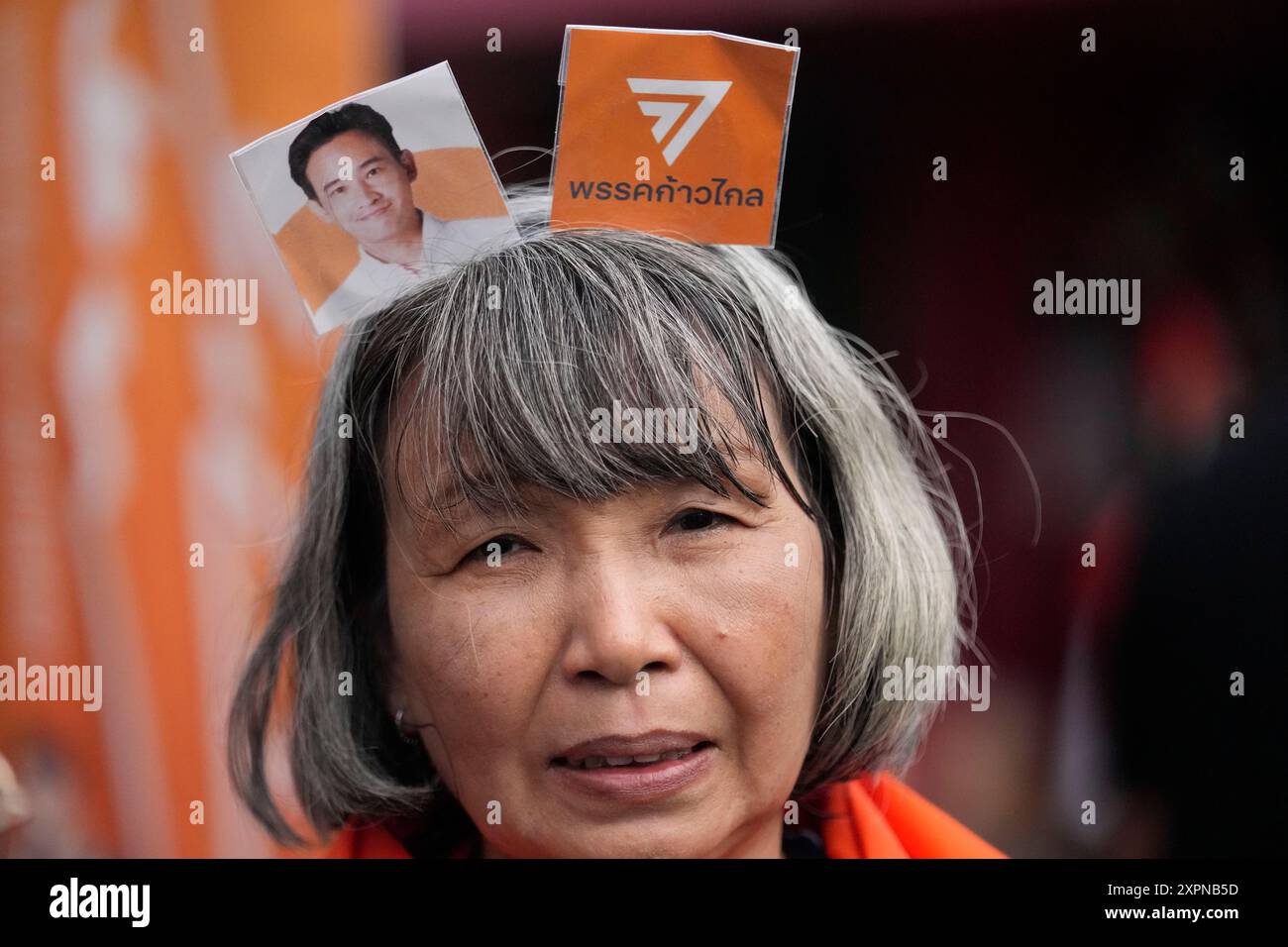 A supporter of Move Forward Party displays a picture of their former leader Pita Limjaroenrat ...