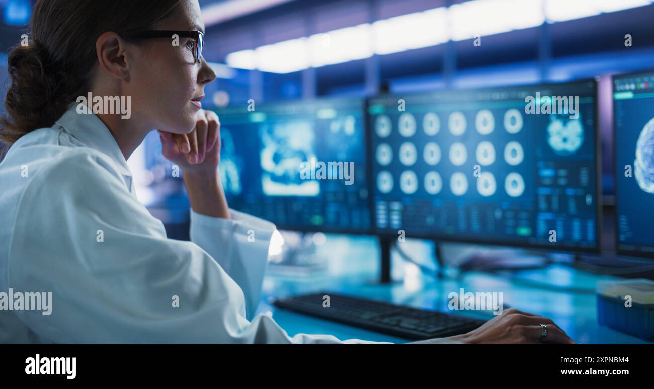Hospital Research Laboratory: Female Medical Scientist Using Computer with Brain Scan MRI Images ...