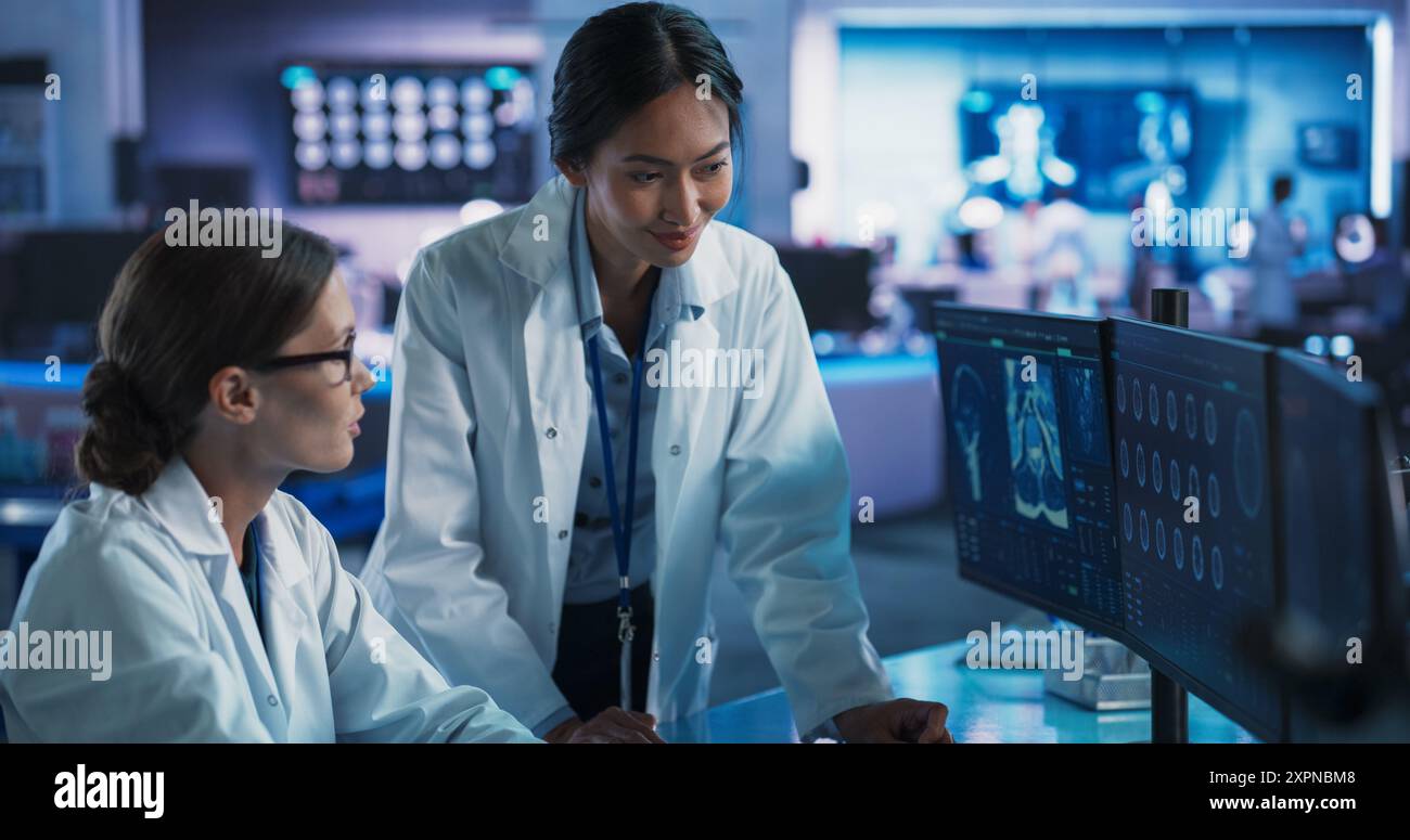 Medical Research Center Laboratory: Caucasian And Asian Female Scientists Talking And Using ...