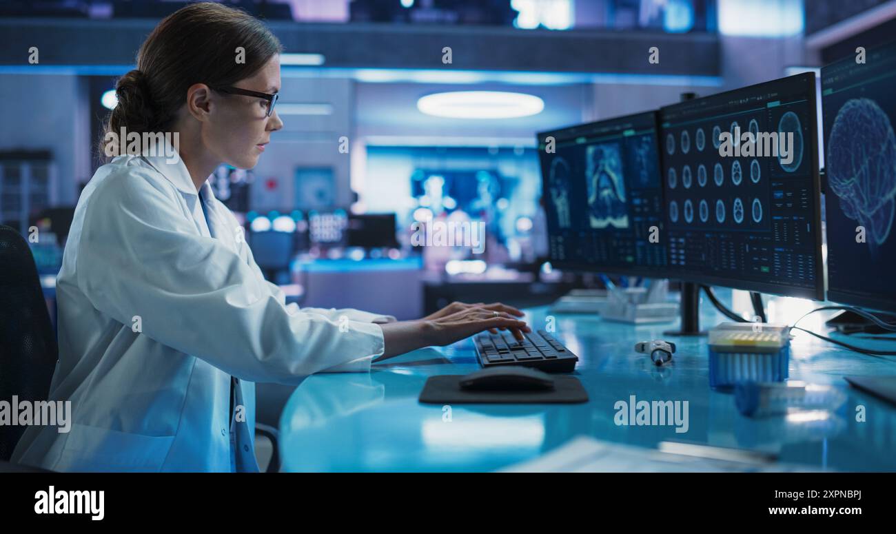 Hospital Research Laboratory: Female Medical Scientist Using Computer with Brain Scan MRI Images ...