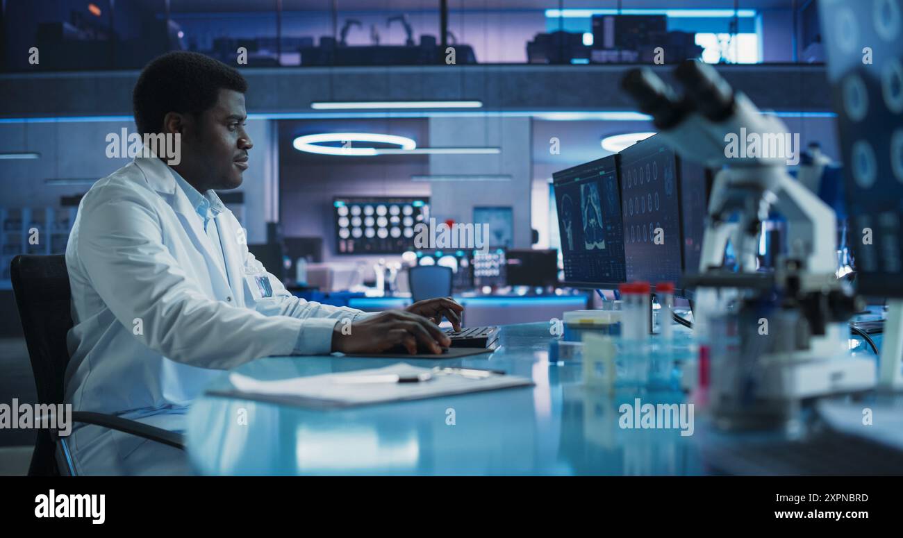 Black Male Neuroscientist Using Desktop Computer To Analyze Mri Scans