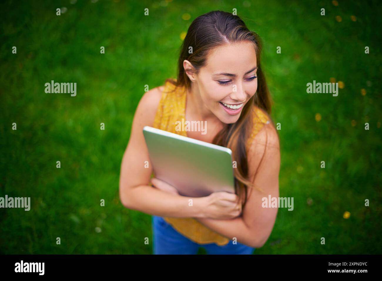 Woman, laptop and happy in outdoor grass, student and campus garden for learning break in park ...