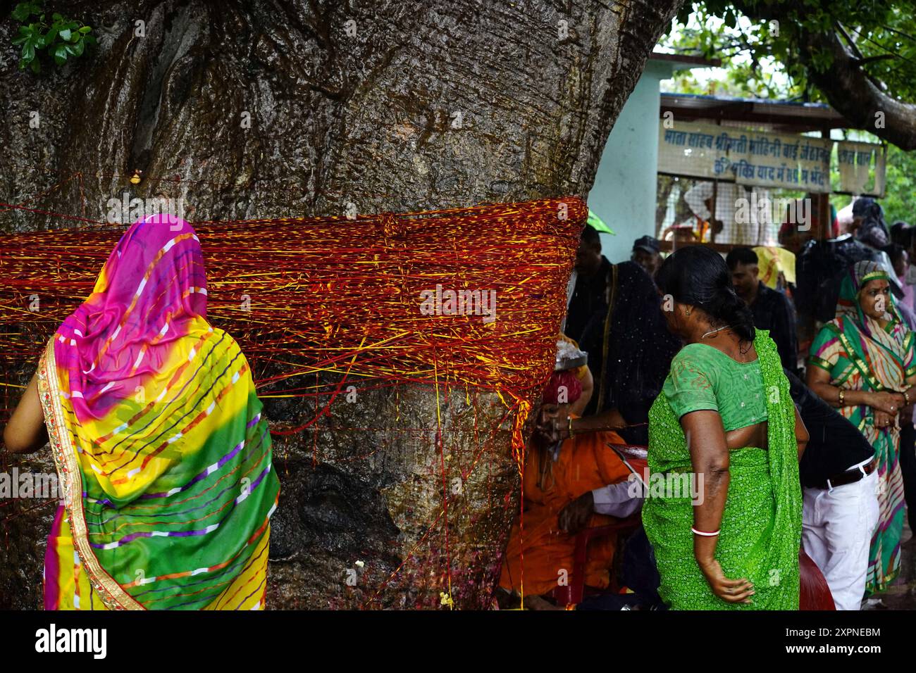Indian Hindu devotee offers prayers as ties a sacred thread to a ...