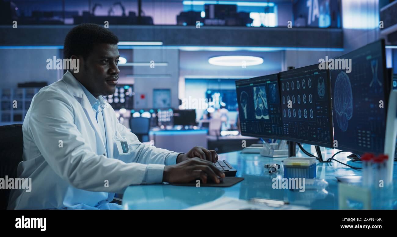 Black Male Neuroscientist Using Desktop Computer To Analyze MRI Scans ...