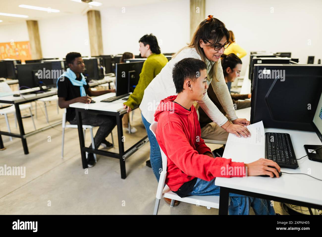 Students using computers software at college IT class - Woman teacher ...