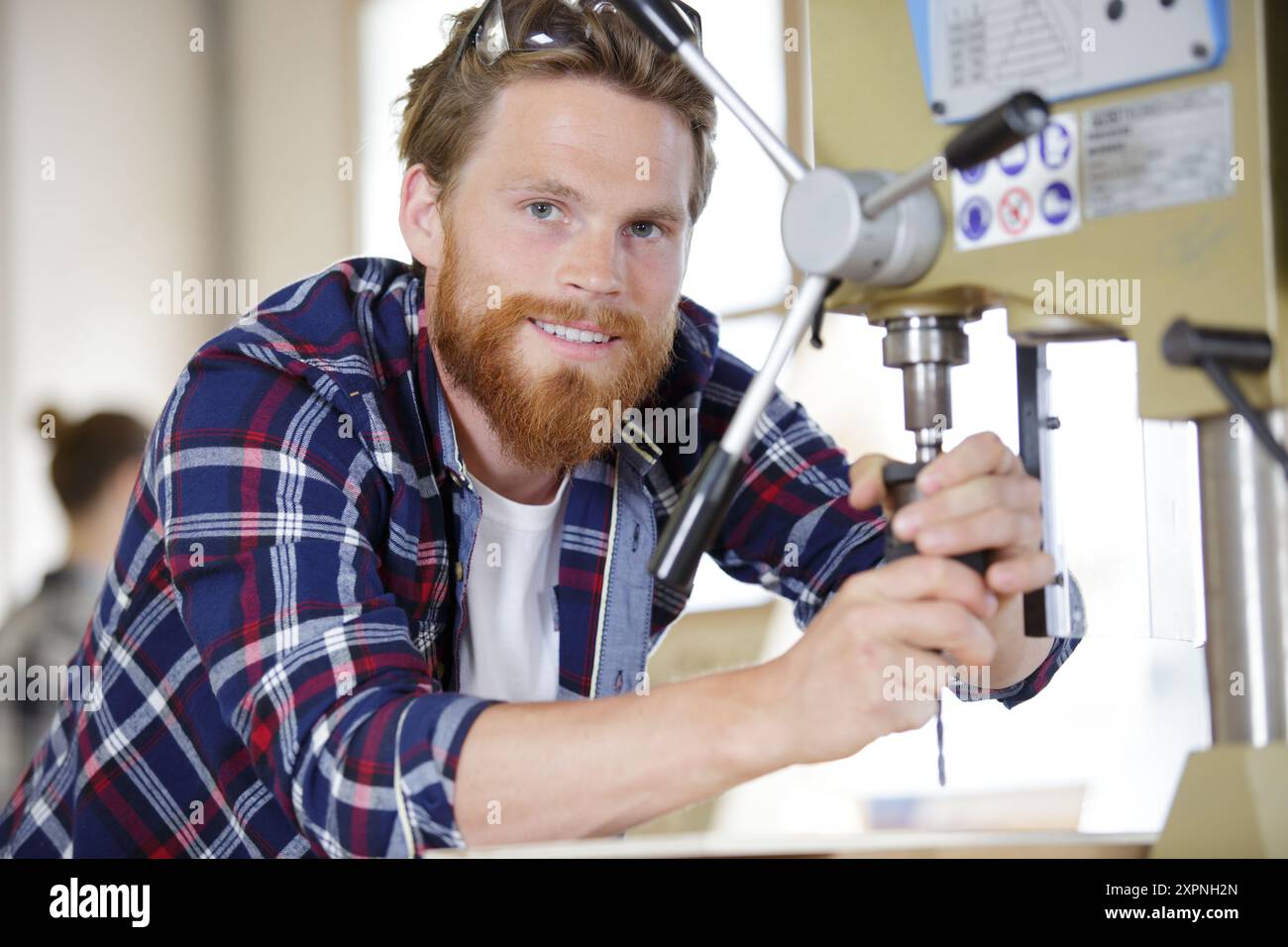 serious craftsman working on drilling machine Stock Photo - Alamy