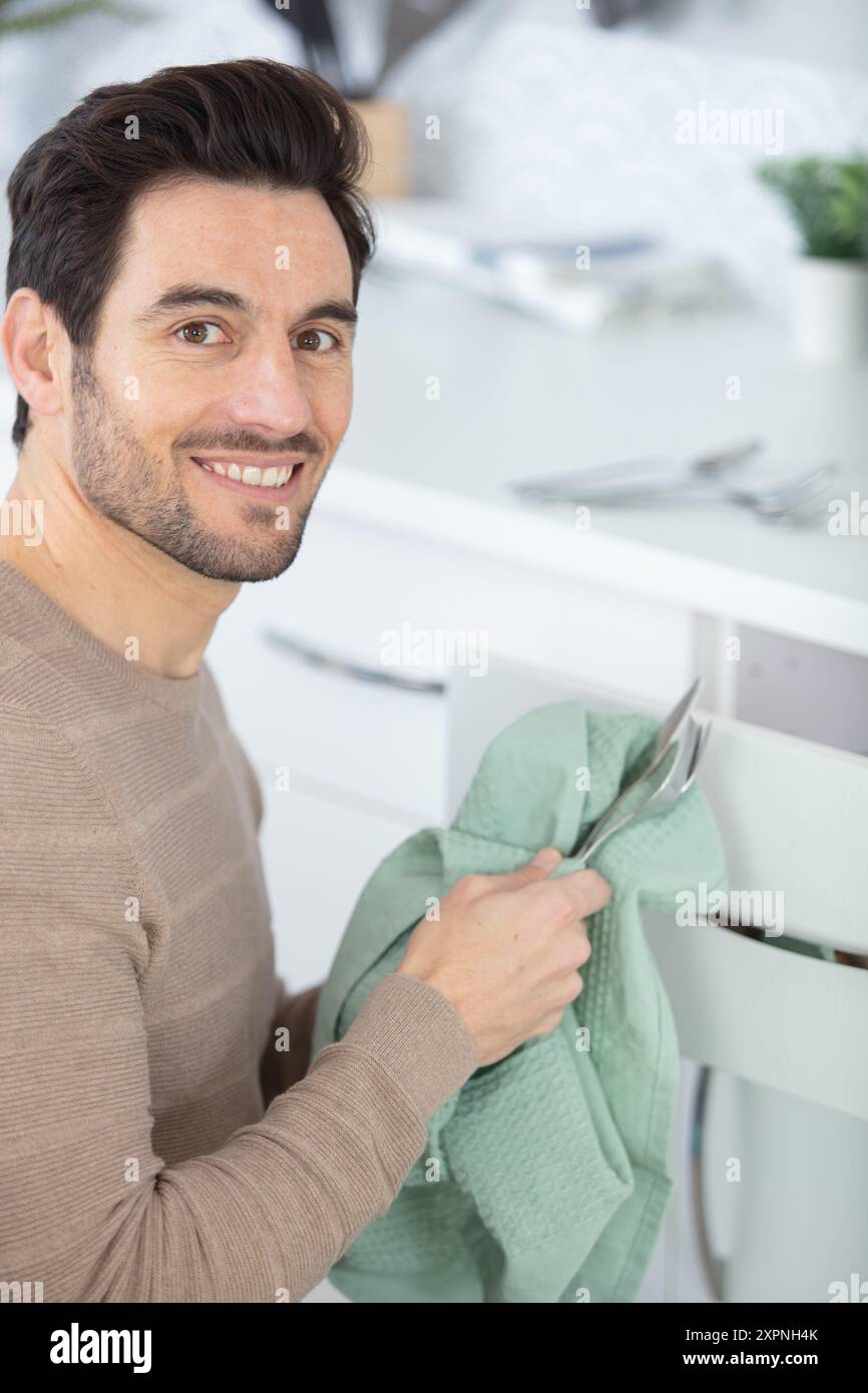 man wiping cutlery in the home Stock Photo - Alamy