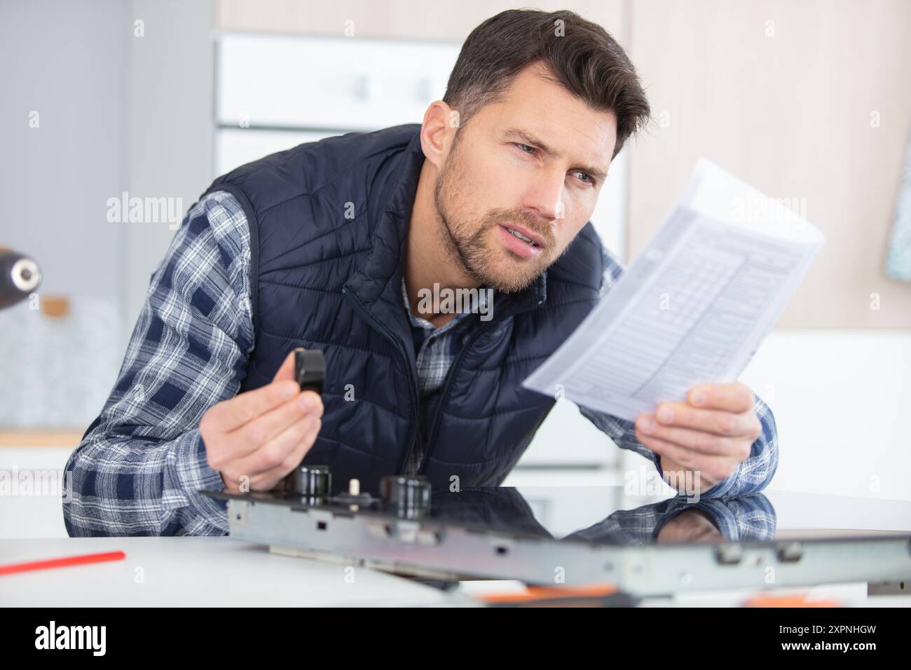man reading instructions for installation of hob Stock Photo - Alamy