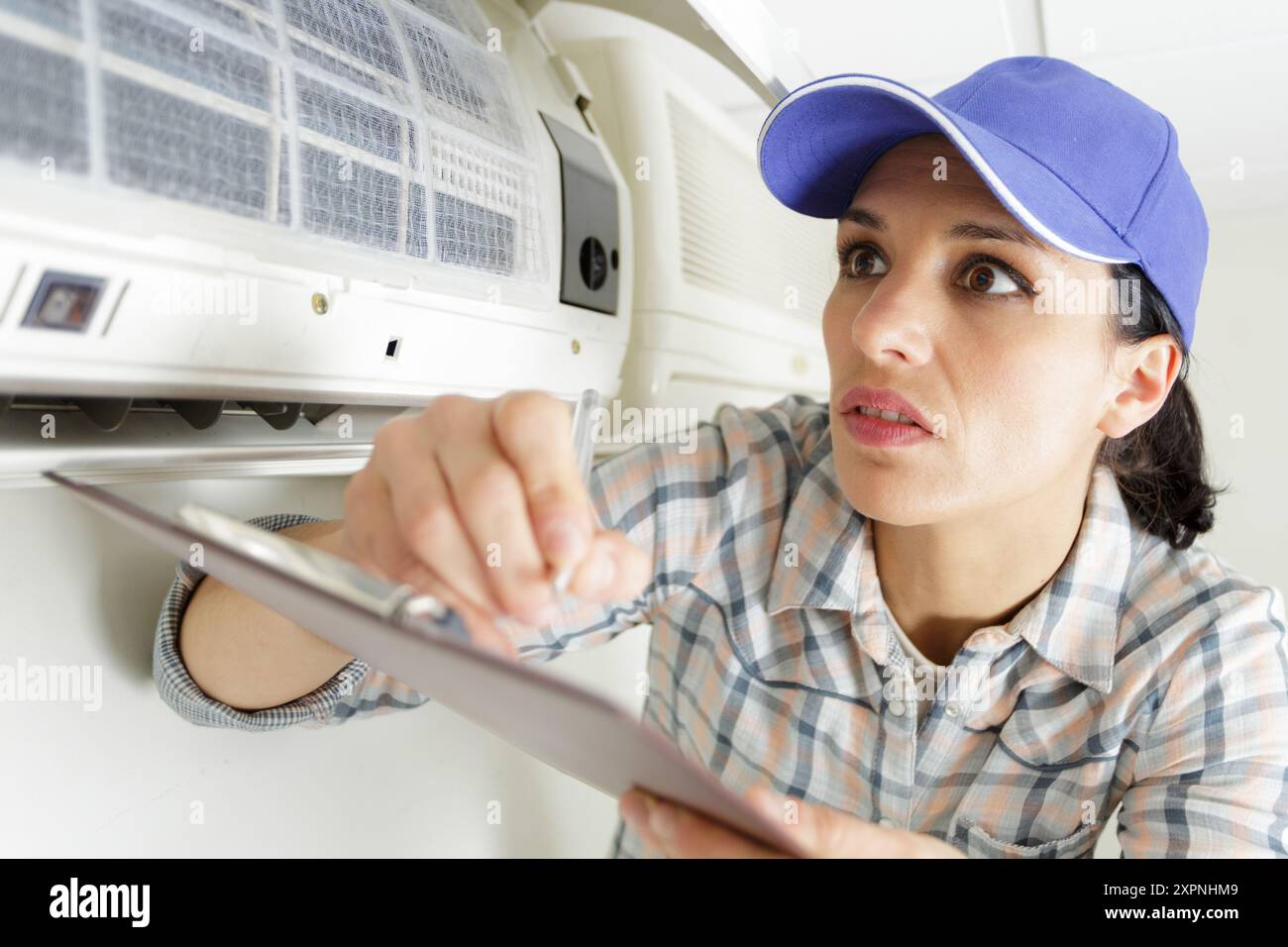 female worker confirms issue with air-conditioning Stock Photo - Alamy