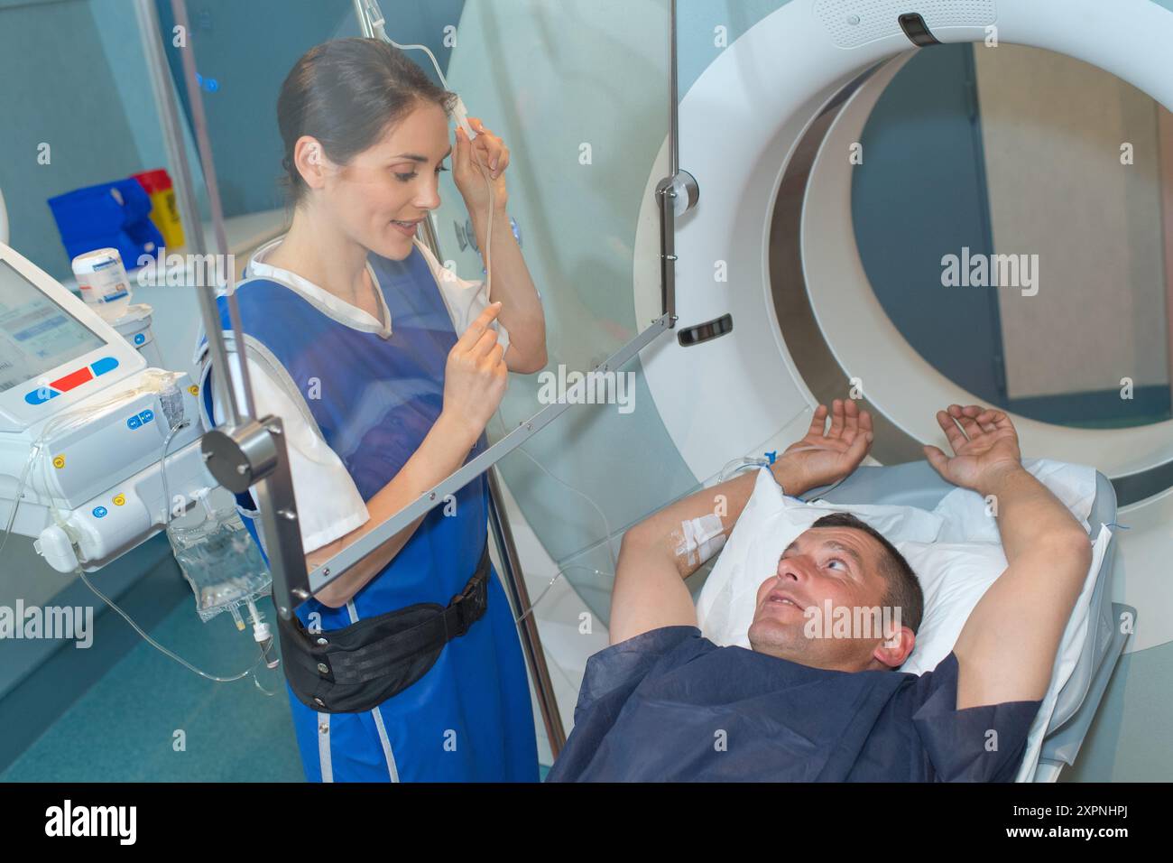 doctor instructing technician while preparing patient for mri scan ...
