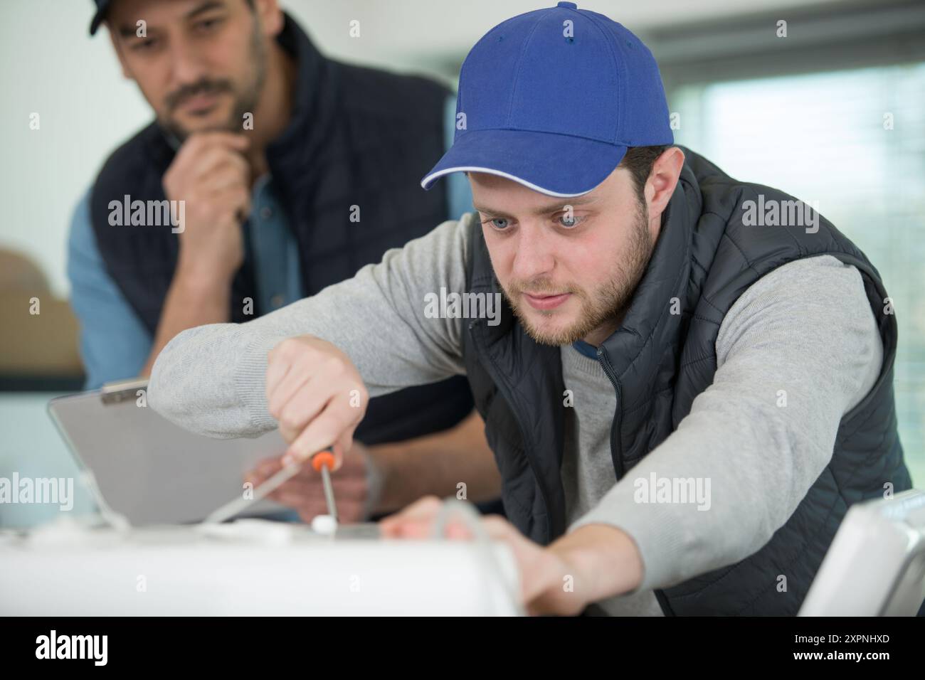 teacher with students in mechanics working on bike Stock Photo - Alamy