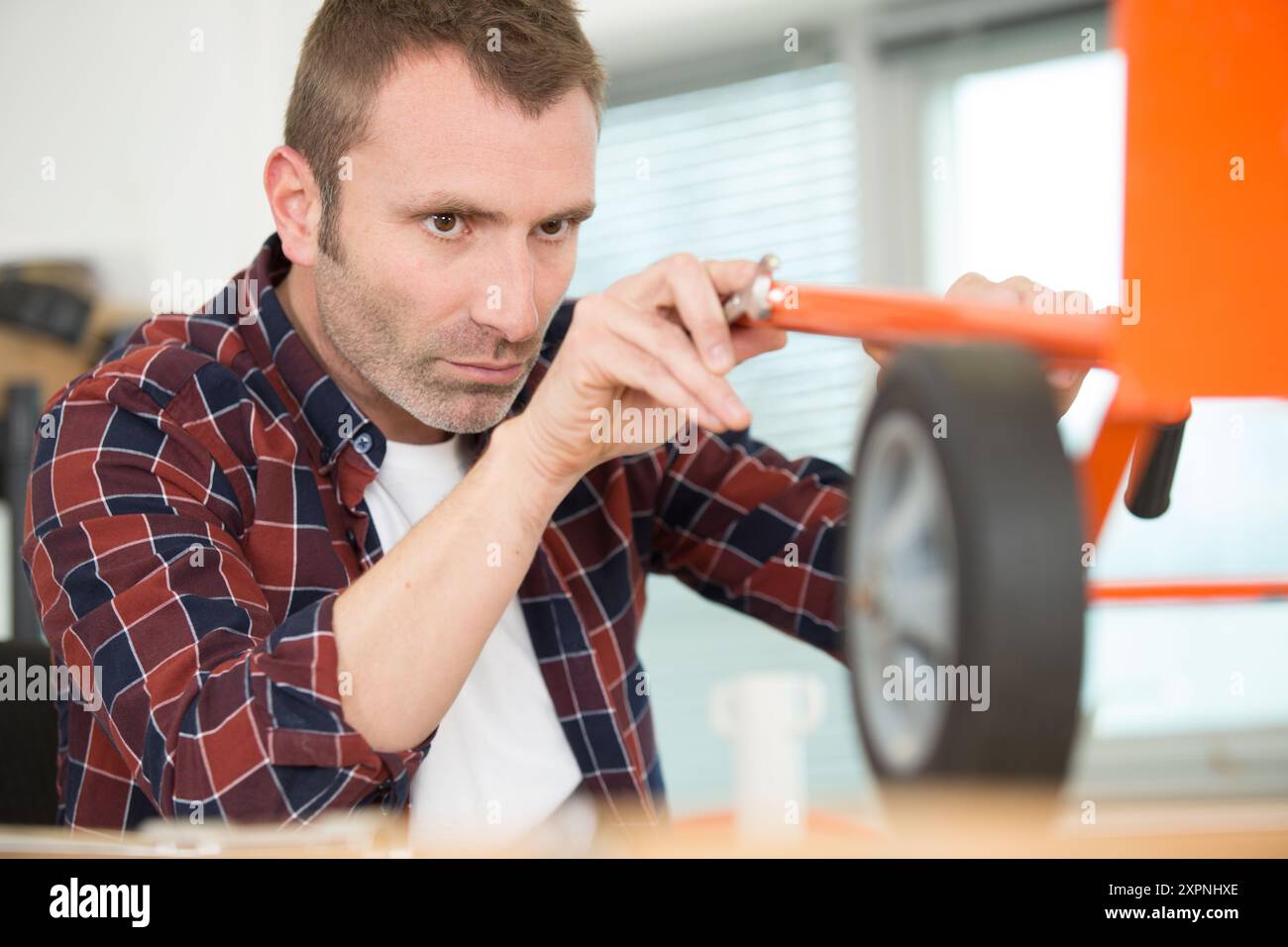 man fixing caster roller wheel Stock Photo - Alamy