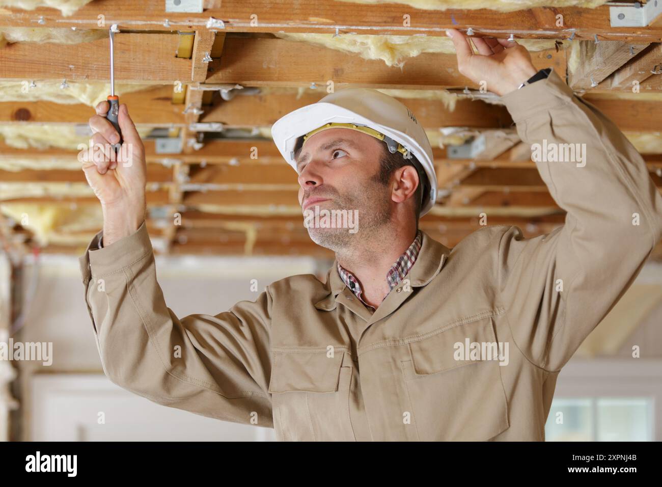 male construction worker using screwdriver on ceiling joist Stock Photo ...