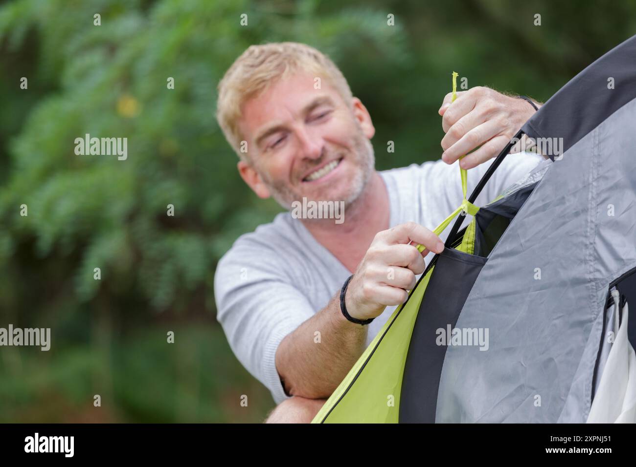 man making tent while camping Stock Photo - Alamy