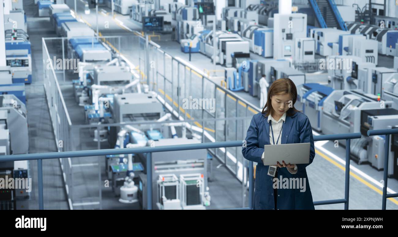 Japanese Factory Specialist Working on Laptop at a Futuristic ...