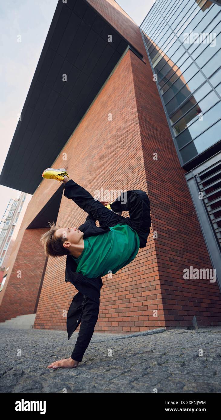 Breakdancer, dressed stylish outfit, performs gravity-defying handstand ...