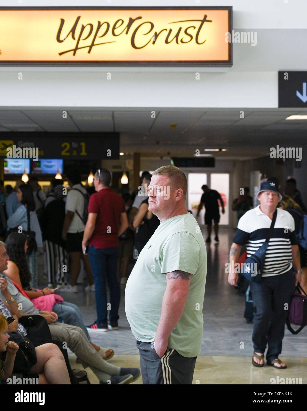 Man standing under "Upper Crust" logo at Lanzarote Airport Stock Photo ...