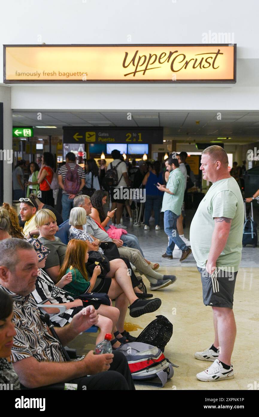 Man standing under "Upper Crust" logo at Lanzarote Airport Stock Photo ...
