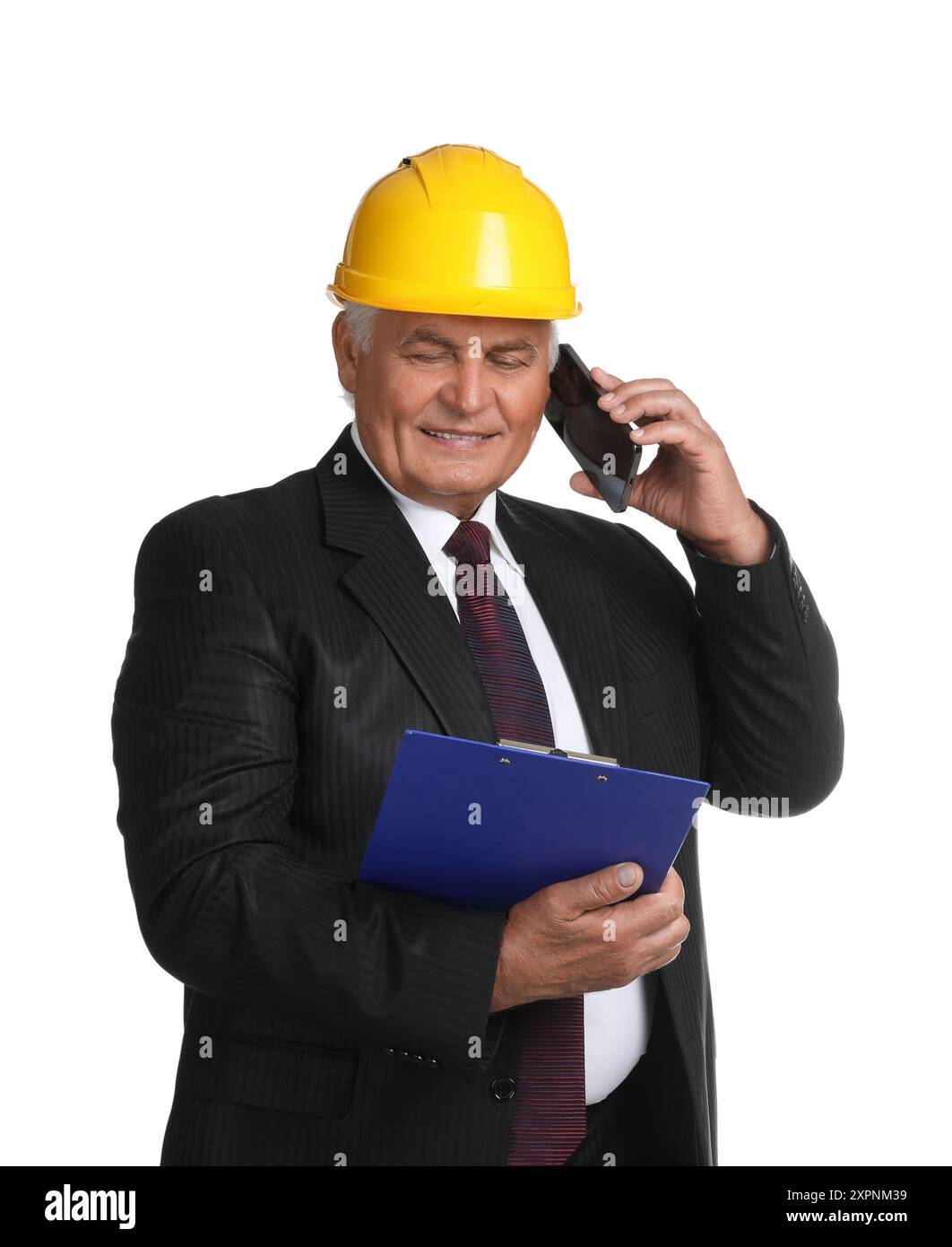 Engineer in hard hat with clipboard talking on smartphone against white ...