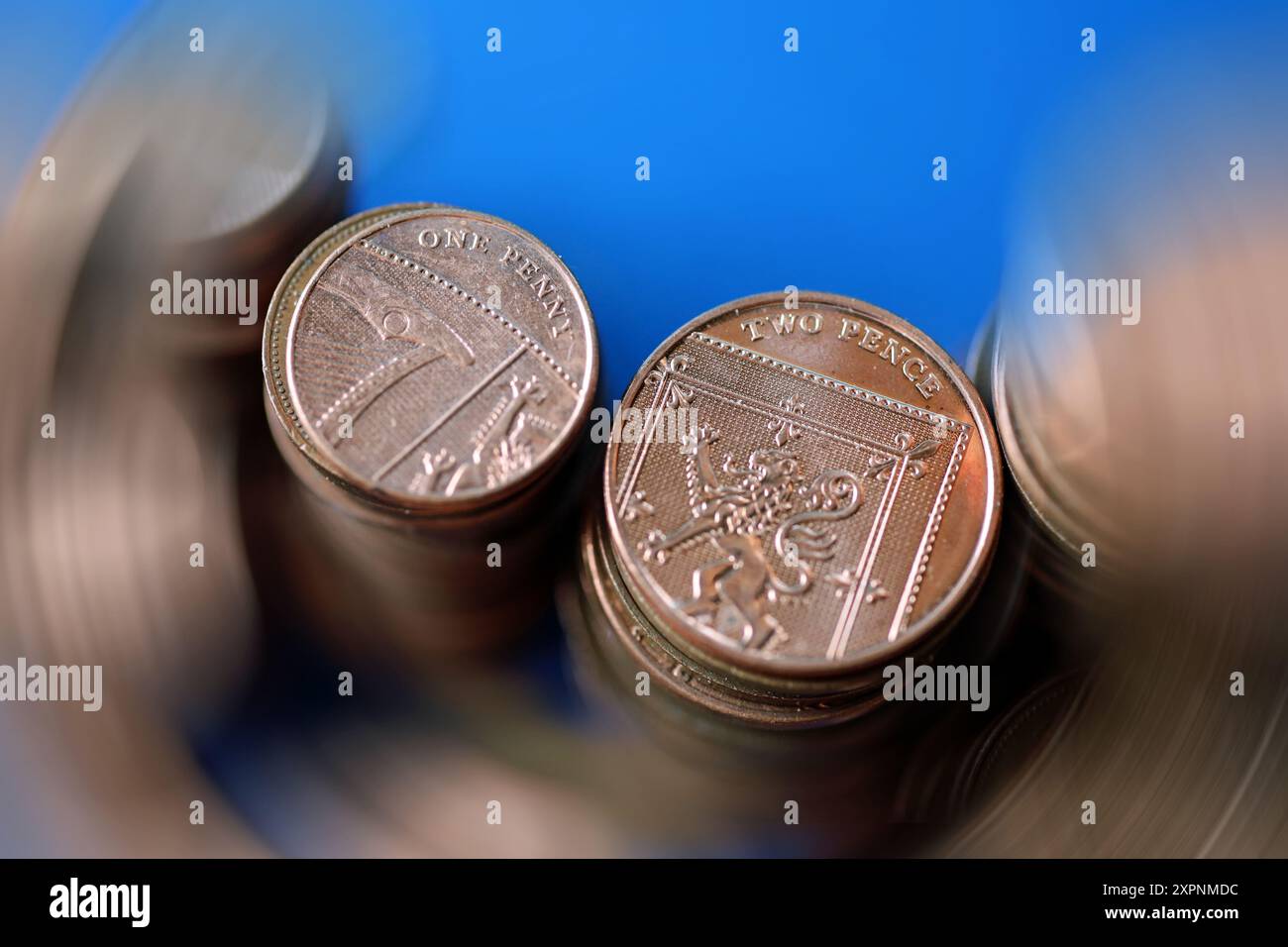 Money go round, a One Penny and Two penny piece in a rotation blur on ...