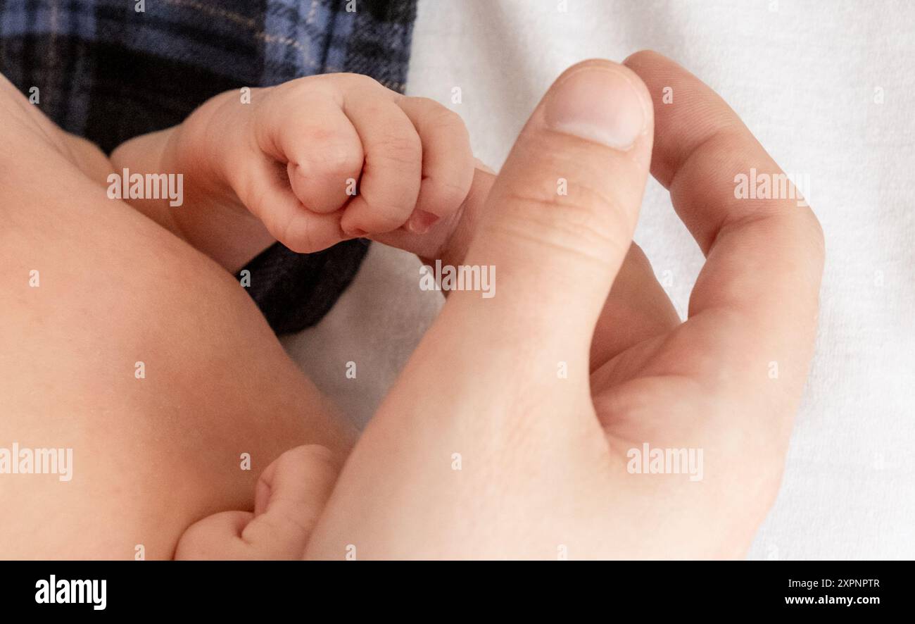 Newborn Baby'S Hand Holds Daddy'S Finger Tightly Stock Photo - Alamy