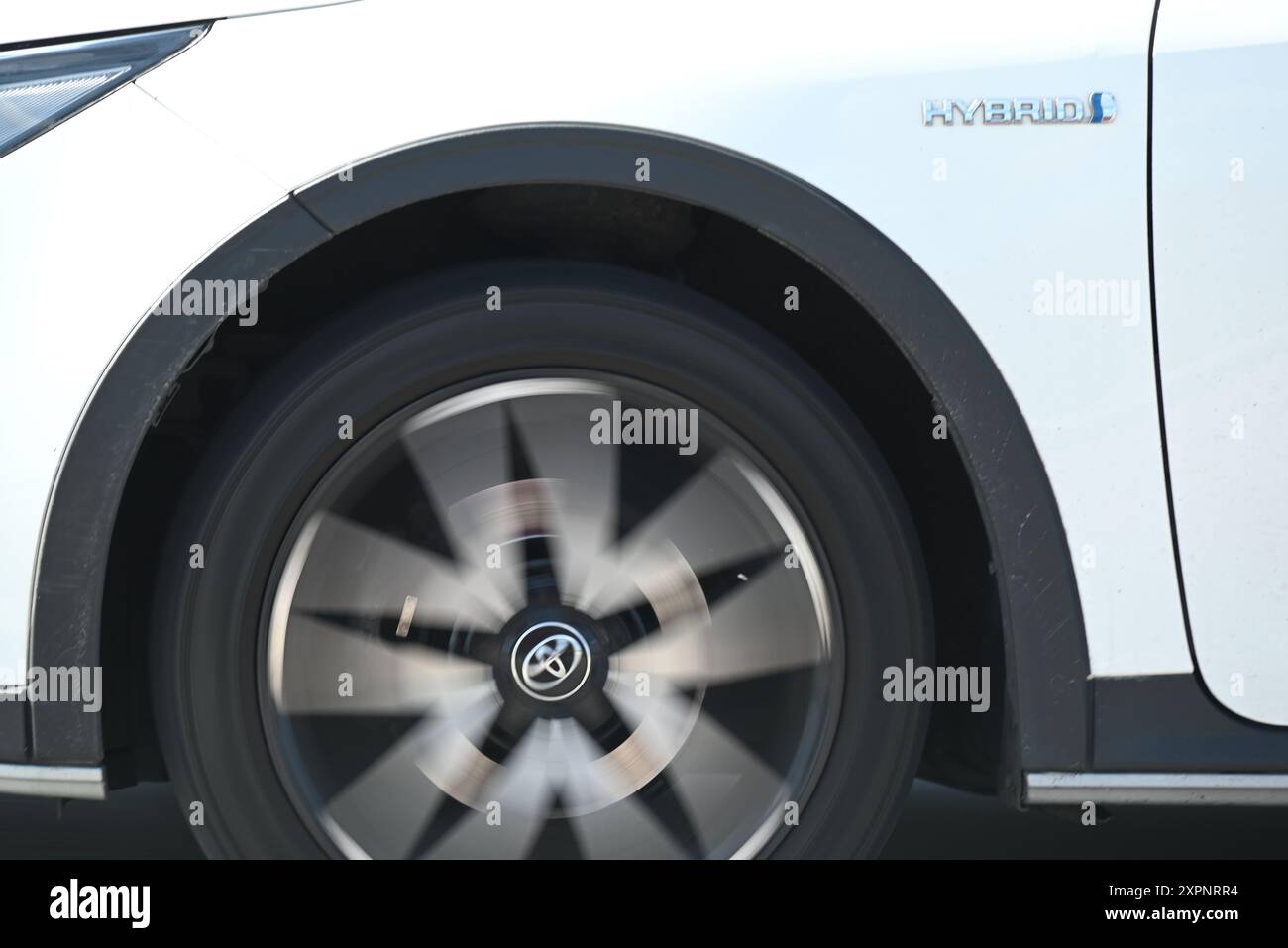 White hybrid car front wheel in action Stock Photo - Alamy