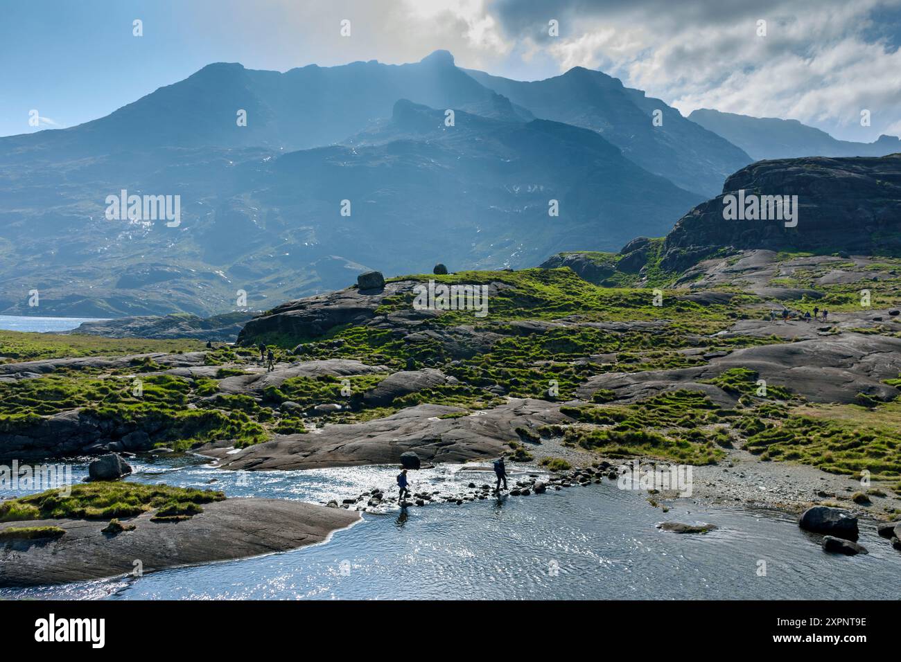 Walkers crossing the stepping stones over the Scavaig river near where ...