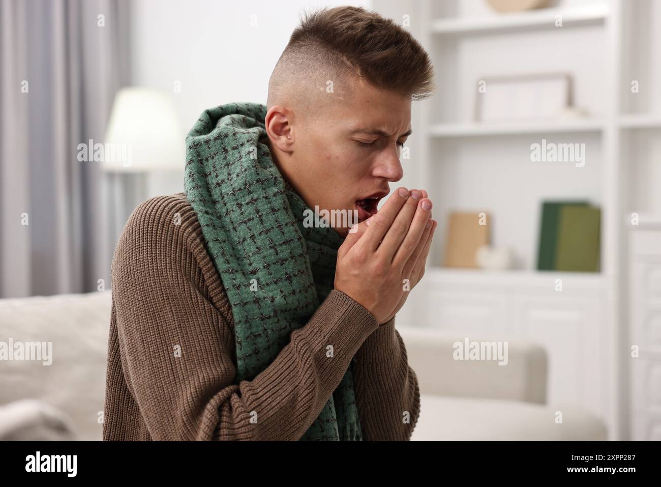 Cold symptom. Young man coughing at home Stock Photo - Alamy