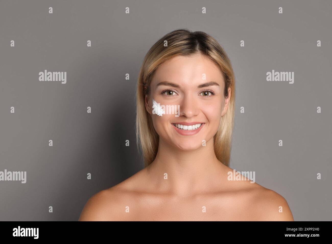 Beautiful woman with cream on her face against grey background Stock ...