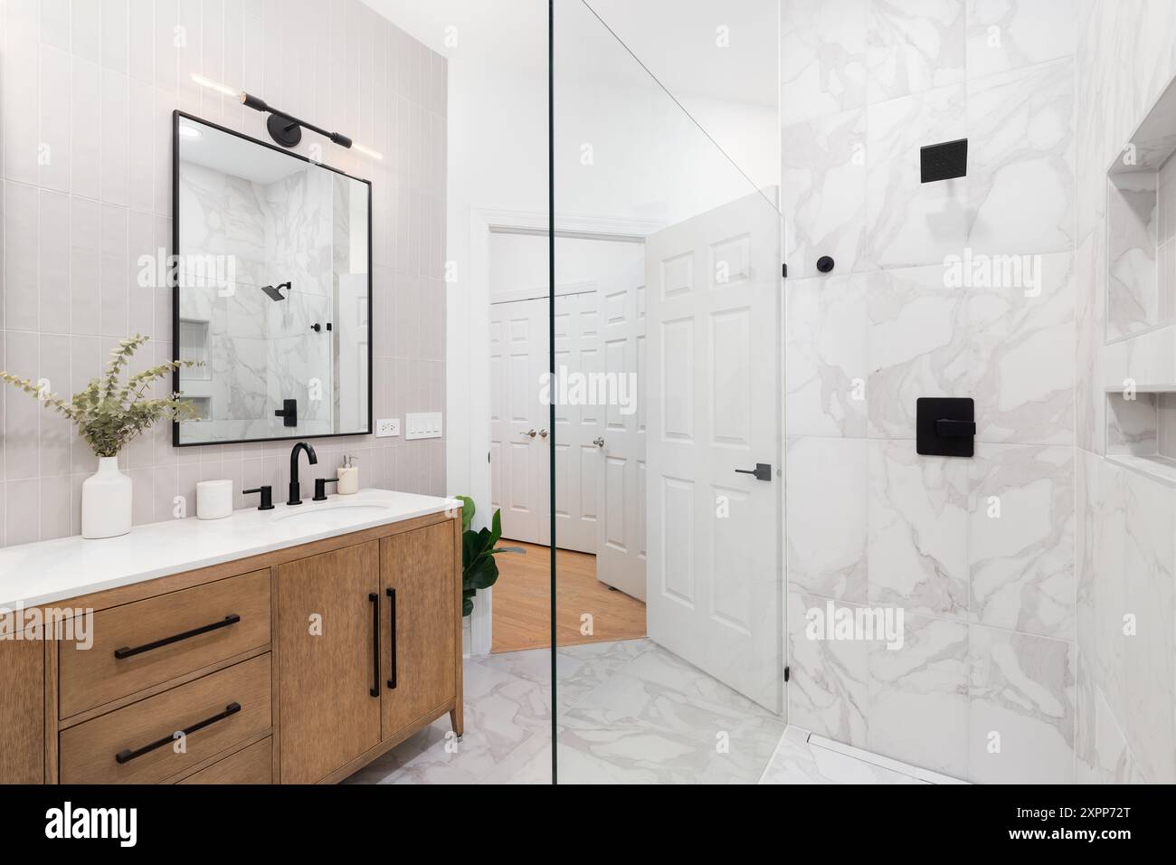 A bathroom detail with a white oak vanity cabinet with a vertical tan ...