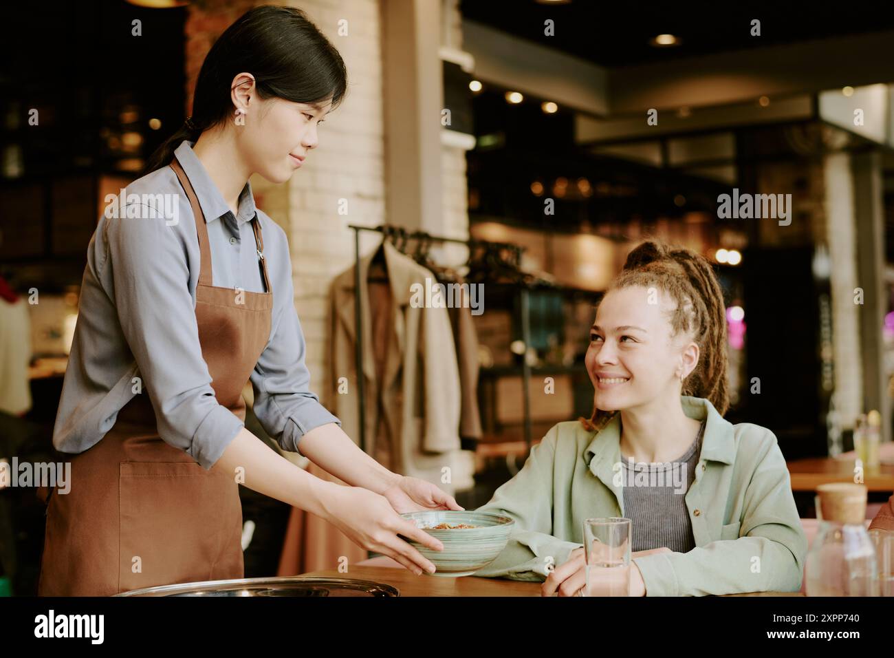 Serving Customer in Cozy Cafe with Warm Ambiance Stock Photo - Alamy