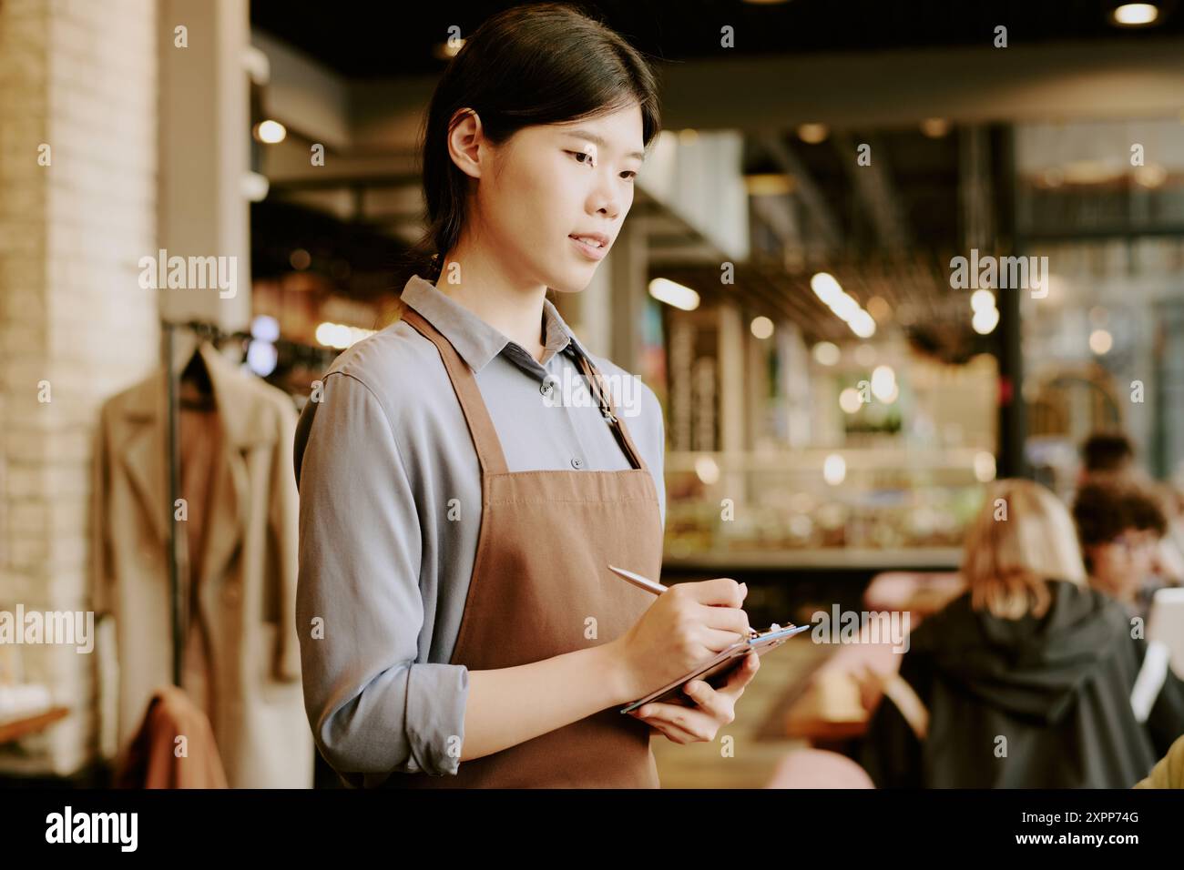Taking Notes in a Restaurant with Serious Expression Stock Photo - Alamy