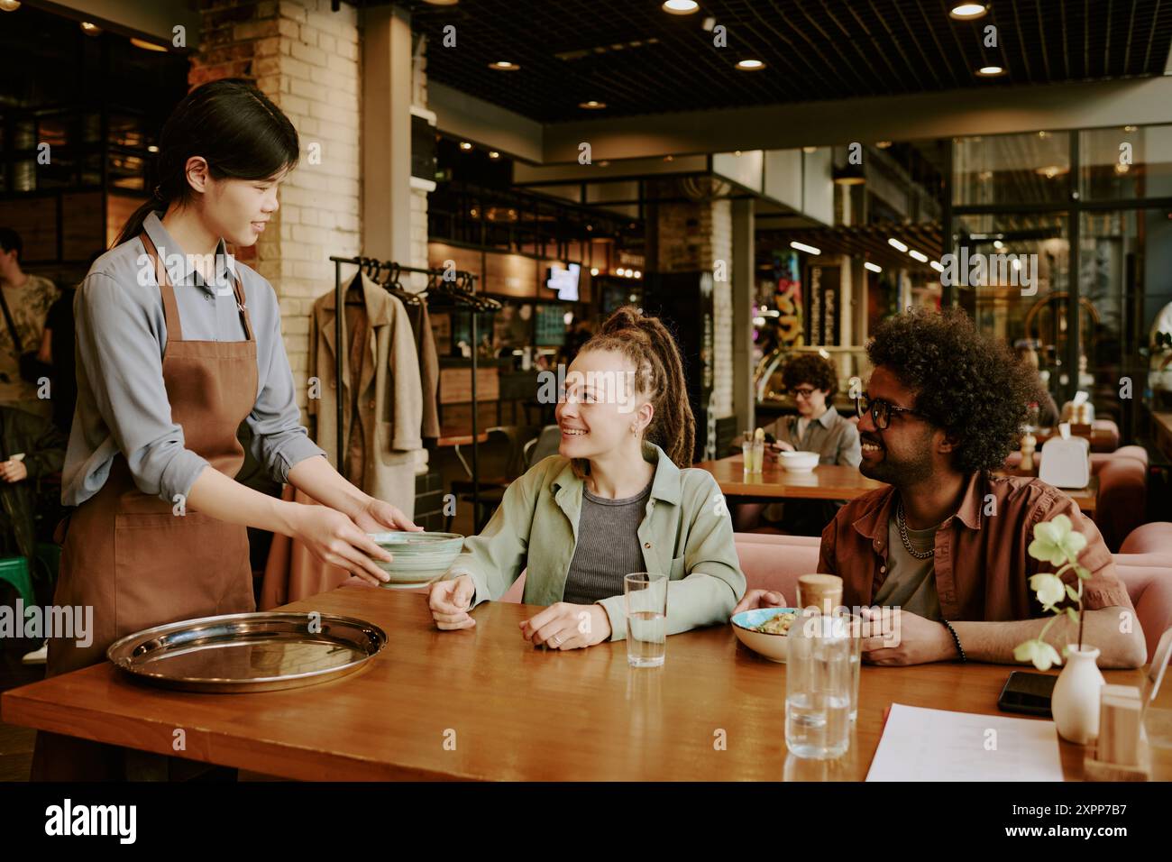 Friendly Server Bringing Dishes at Cozy Restaurant Stock Photo - Alamy